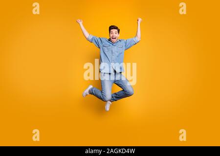 Full length photo of excited lucky man wear green t-shirt rising fists ...