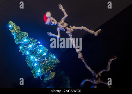A skeleton dancing around a Christmas Tree with lights Stock Photo - Alamy