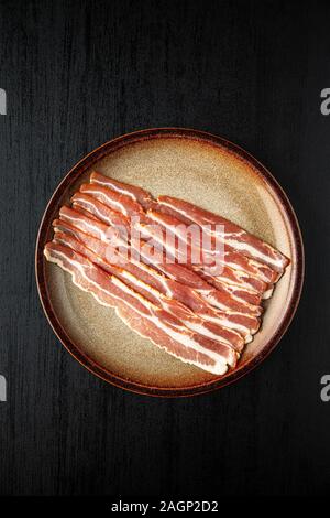 Smoked bacon strips on plate. Top view Stock Photo - Alamy