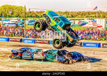 monster truck jumping over crushed cars in a race Stock Photo - Alamy