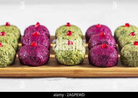 Pkhali with beets and beans on a cutting board on a white background ...