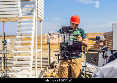 Steadicam operator and his assistant prepare camera and 3-axis ...