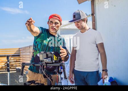 Steadicam operator and his assistant prepare camera and 3-axis ...