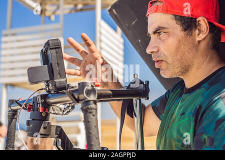 Steadicam operator and his assistant prepare camera and 3-axis ...