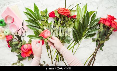 Flat lay. Florist running red roses for bouquet arrangement Stock Photo ...