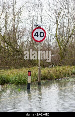 Earith, UK. 22nd Dec, 2019. A woman walks through a flooded road as the ...