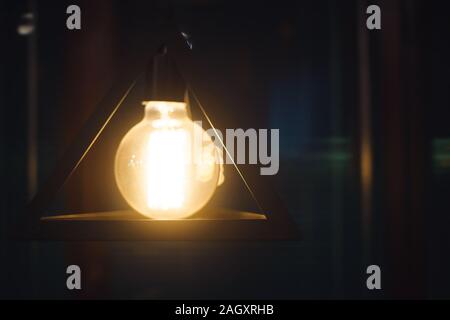 Ceiling light. Light bulb in triangular metal structure Stock Photo - Alamy