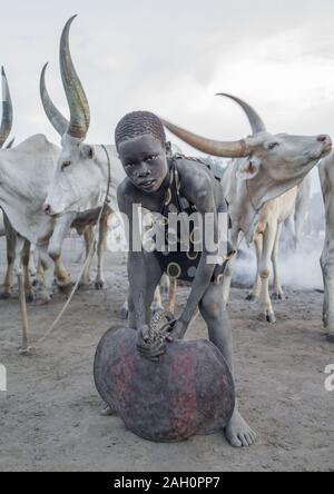 Mundari tribe boy with a bell taking care of the cows in the camp, Central Equatoria, Terekeka ...