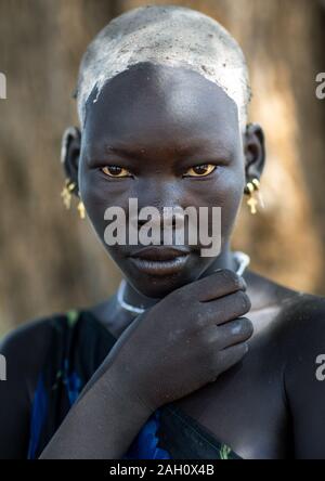 Portrait of a beautiful Mundari young woman with ash on the head to dye her hair in red, Central ...