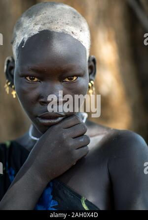 Portrait of a beautiful Mundari young woman with ash on the head to dye ...