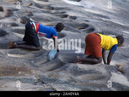 Lotuko tribe woman grinding grains in a hole in the rock, Central ...