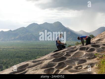 Lotuko tribe woman grinding grains in a hole in the rock, Central ...
