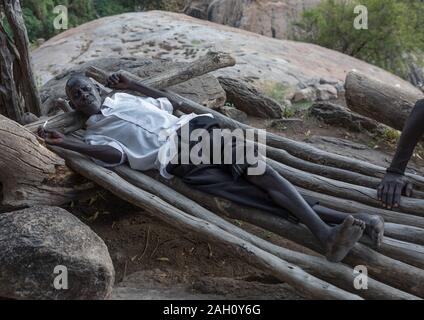 Lotuko tribe man resting on a wood bed, Central Equatoria, Illeu, South ...