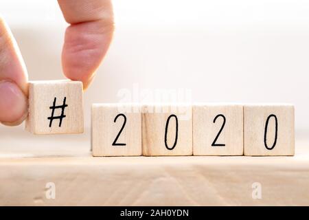 Hashtag 2020 concept, hand change wooden cubes close-up with white ...