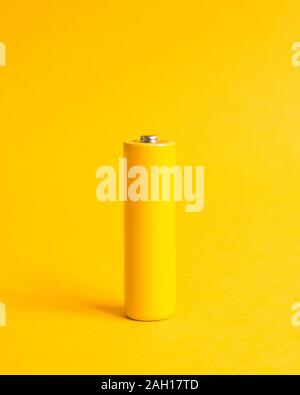 Single yellow battery on a yellow pastel background Stock Photo - Alamy