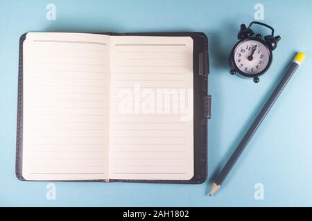 Calendar with alarm clock, notebook, paper pins and pen on beige ...