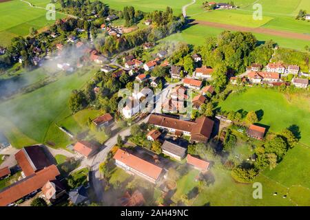 Germany, Bavaria, Dorfen, Aerial view of fog floating over green forest ...