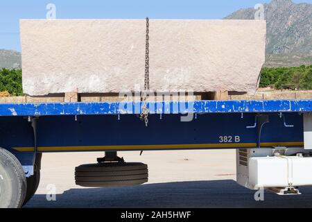 Large block of stone being transported on a semi truck and flatbed ...