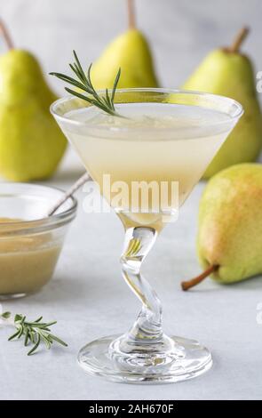 Pear cocktail with pear puree and fresh fruit and flowers on light gray ...