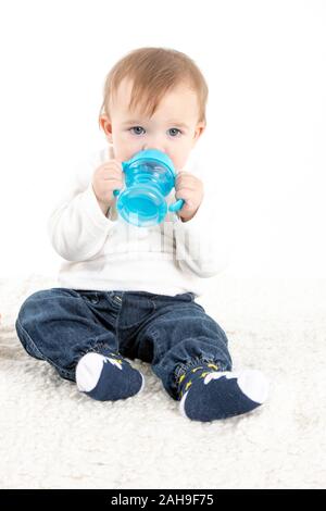 Adorable toddler drinking water sitting on sofa at home Stock Photo - Alamy
