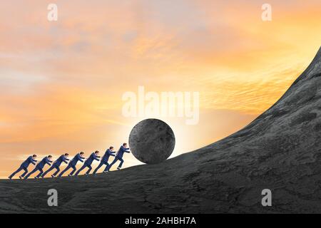 The team of people pushing stone uphill Stock Photo - Alamy