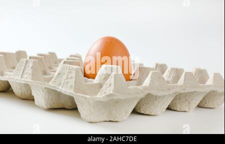 One brown egg left in a twenty dimpled egg tray Stock Photo - Alamy