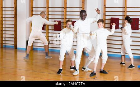 Fencing instructor explaining to young fencers an effective movements ...