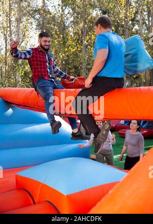 Males fighting on log at outdoor amusement playground Stock Photo - Alamy