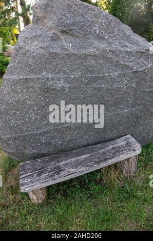 Huge boulder and old bench in the garden Stock Photo - Alamy