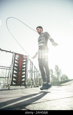 Man using a jumping rope to improve muscle strength Stock Photo - Alamy