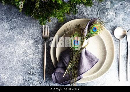 Festive table setting decorated with peacock feather for Christmas ...