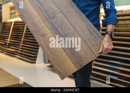 flooring store salesman with laminate floor sample panel in hands Stock ...