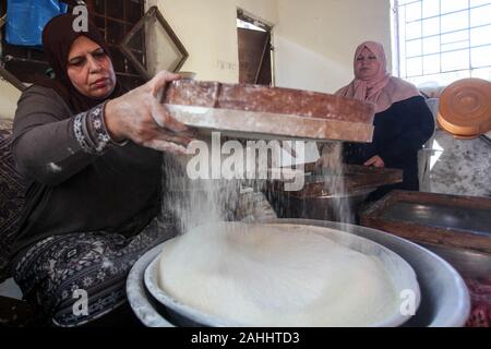 Palestinian women prepare "Maftoul", a traditional couscous dish made ...