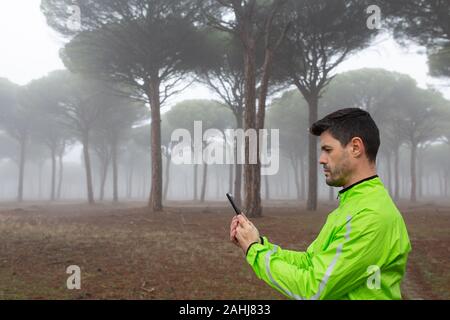 A guide looks at his phone and a map in a backcountry hut in the ...