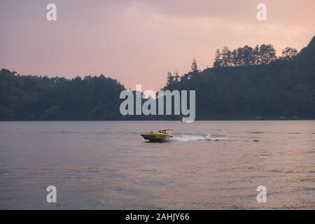 Tourist boat on Ngebel Lake at sunset, Ponorogo, East Java, Indonesia ...