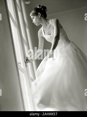 An anxious bride is standing near a window Stock Photo - Alamy