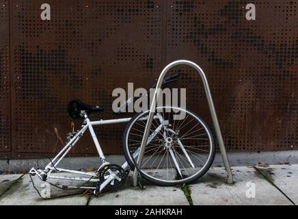 A disabled bicycle chained to permanent bike racks in Seattle's ...
