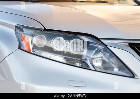 Front headlamp view of silver used car stands in the auto showroom sale ...