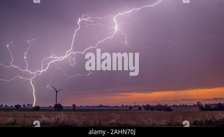 Severe lightning at sunrise pictured around a wind turbine Stock Photo ...