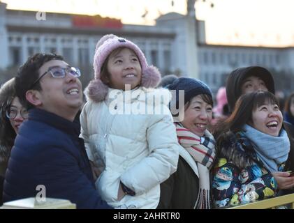 People watch the national flag-raising ceremony in Tiananmen Square to ...
