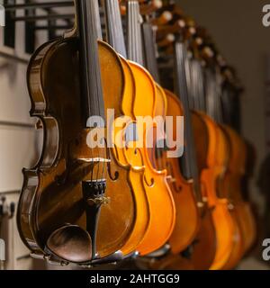Violins hanging on display in a music shop Stock Photo - Alamy
