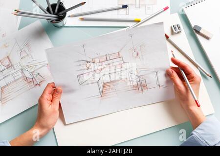 Interior designer holding pencil sketch of a kitchen in a process of ...