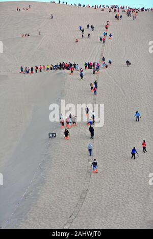 Sled-riders on the dunes around Crescent lake-Yueyaquan oasis. Dunhuang ...