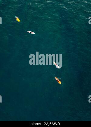 A group of surfers in the ocean, with four surfers visible in the water ...