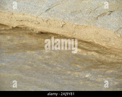 Water flowing over sand forming pattern Stock Photo - Alamy