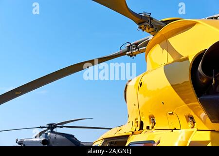 Close up of the rotors blades of a yellow Helicopter against a bright ...