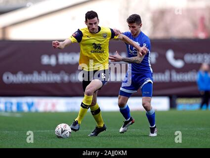 Oxford United's Elliott Moore (left) heads the ball clear during the ...