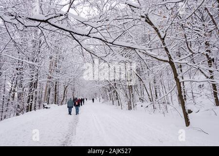 People walk in a parc in a snowy landscape pictured in Namur on Monday ...