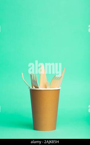 Bamboo spoons and forks in a paper plate on a wooden table/Still life ...