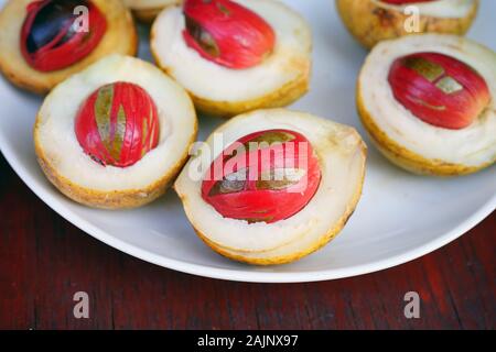 Fresh nutmeg (mace) seed pods in a red shell Stock Photo - Alamy